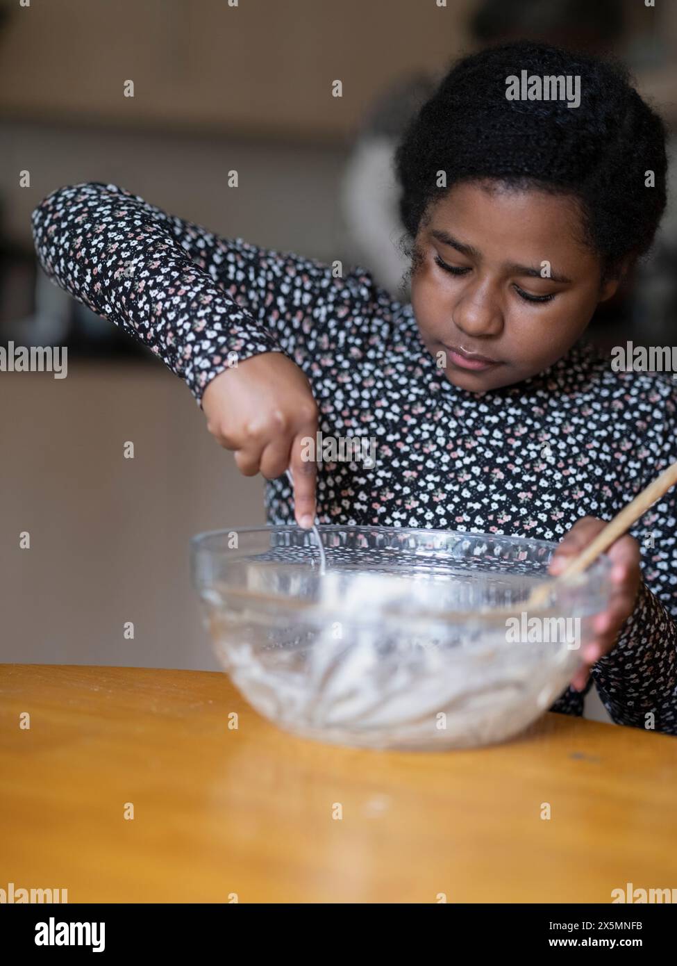 Girl eating cookie batter from bowl Stock Photo - Alamy