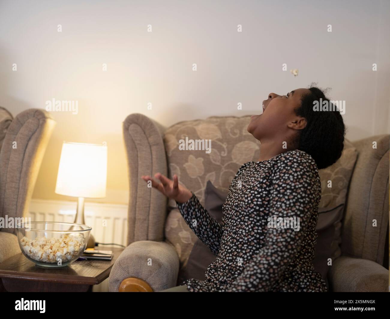 Girl trying to catch popcorn in mouth Stock Photo - Alamy