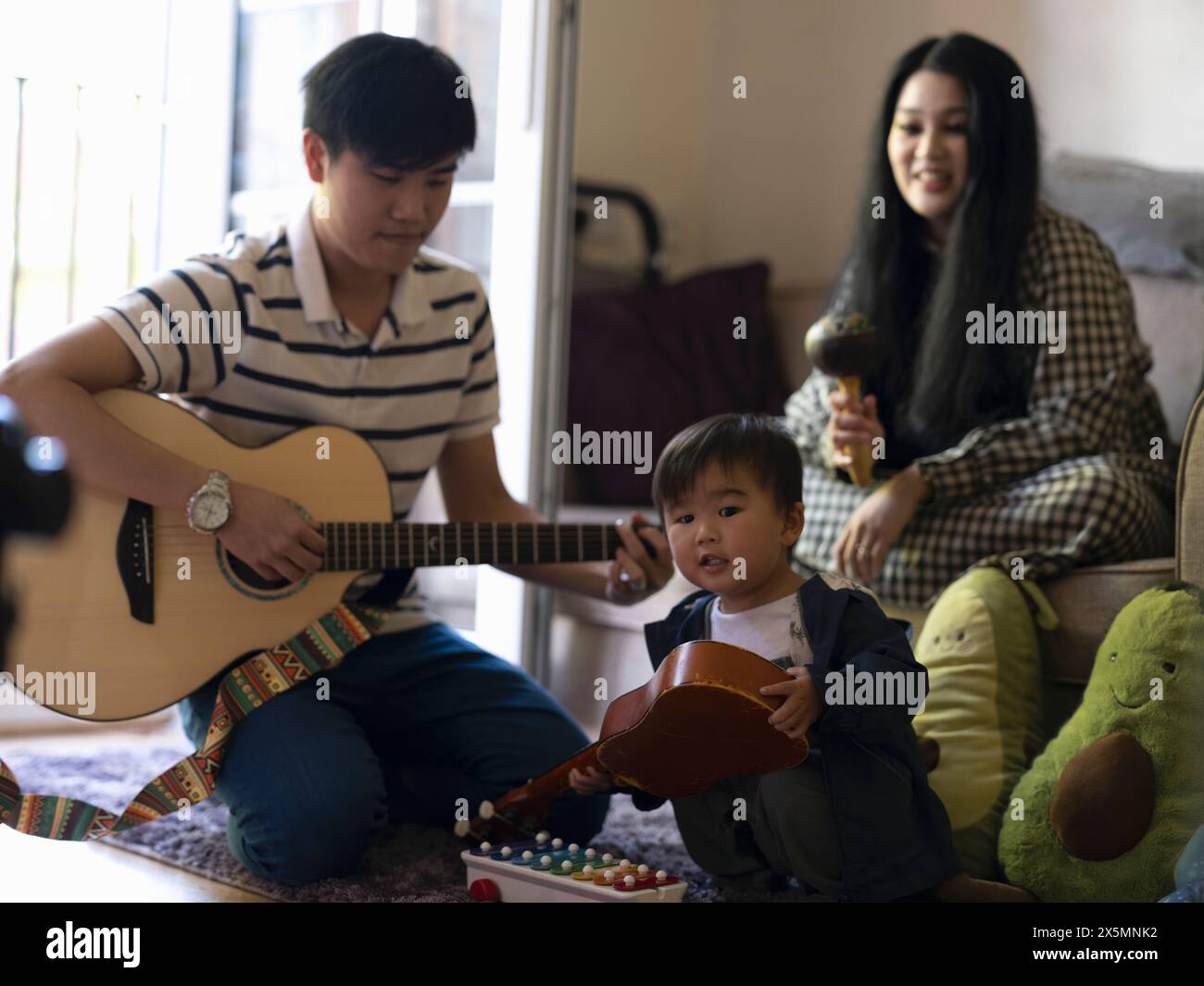 Parents and baby son playing instruments at home Stock Photo - Alamy
