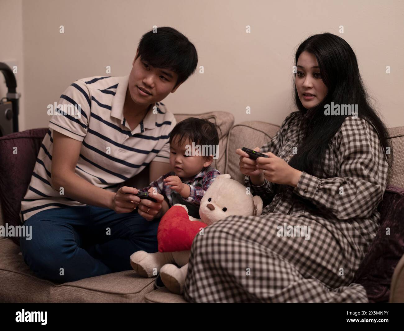 Parents with baby son playing video games Stock Photo - Alamy