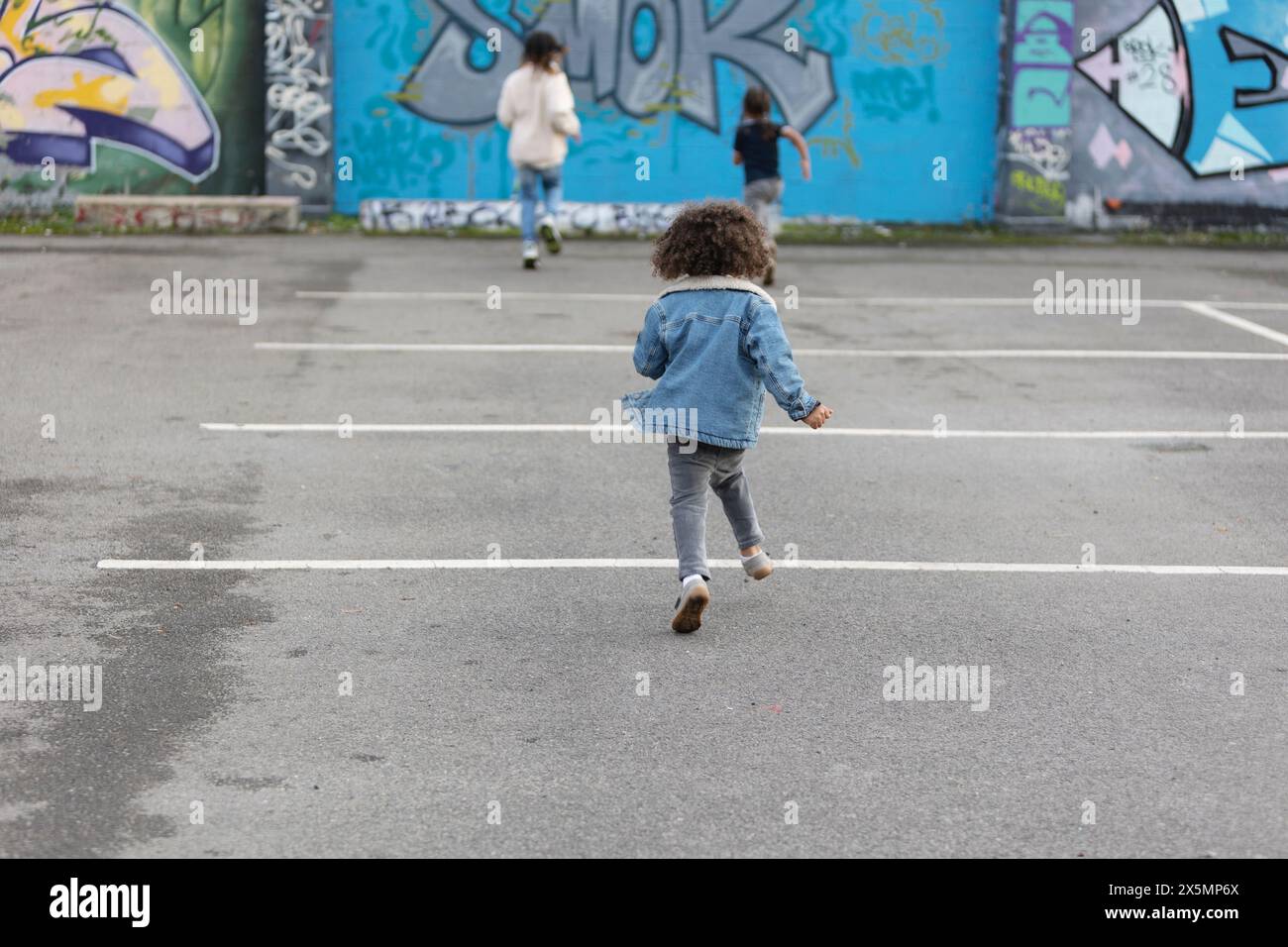 Brothers running on parking lot Stock Photo - Alamy