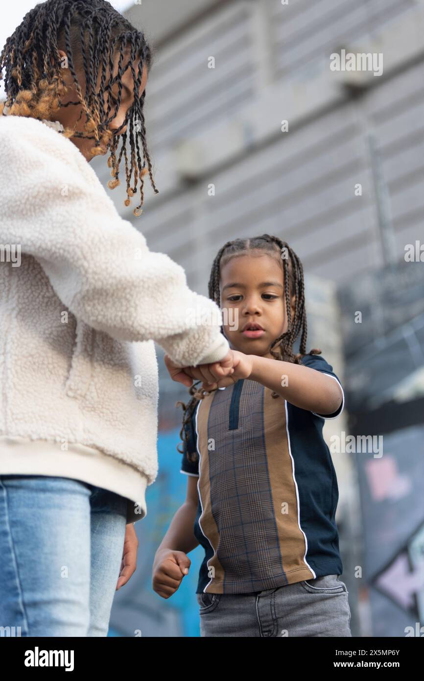 Fist bump greeting between two brothers Stock Photo - Alamy