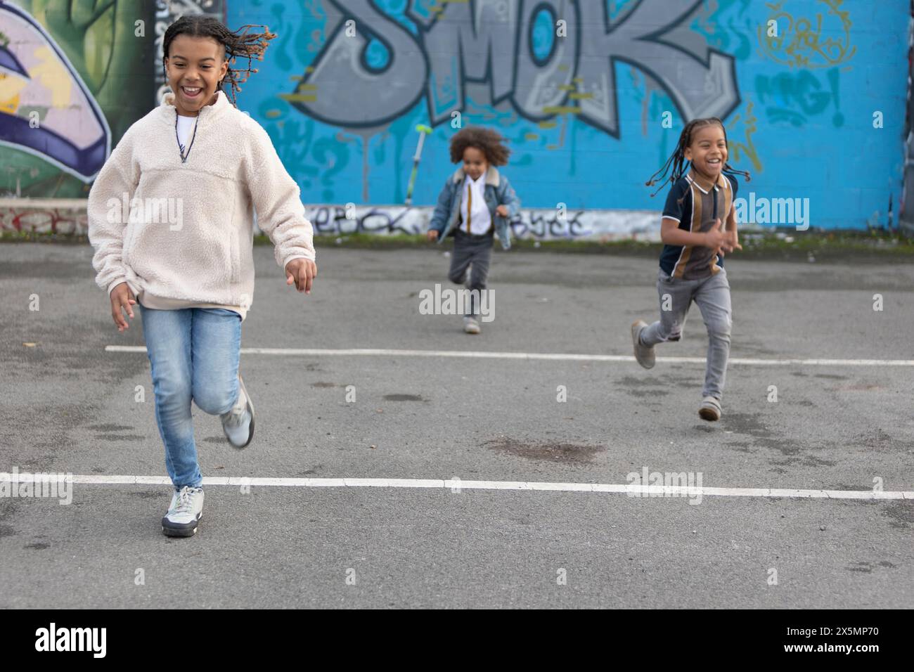 Brothers running on parking lot Stock Photo - Alamy