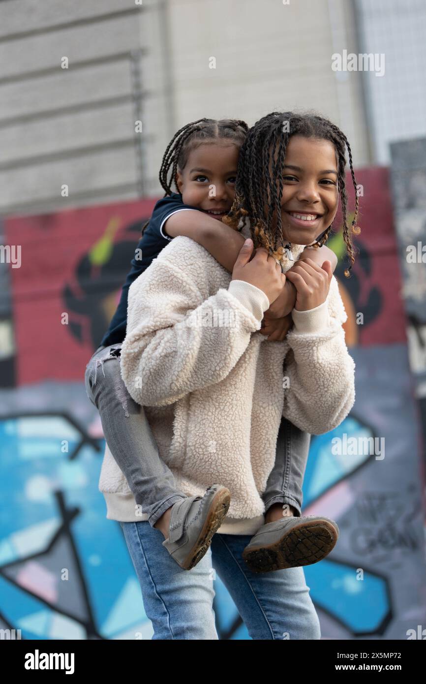 Portrait of boy giving piggyback ride to younger brother Stock Photo ...