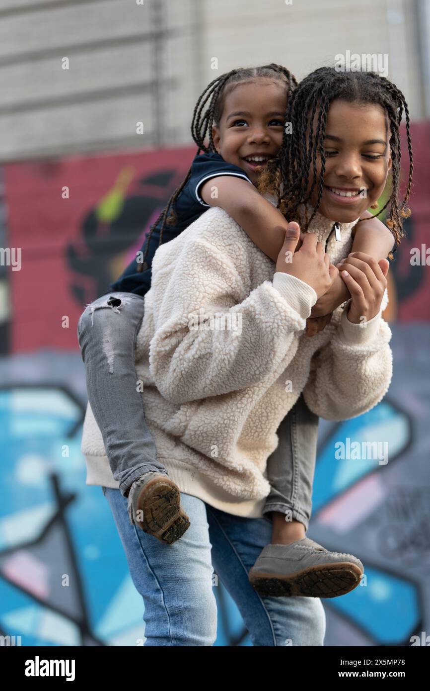 Portrait of boy giving piggyback ride to younger brother Stock Photo ...