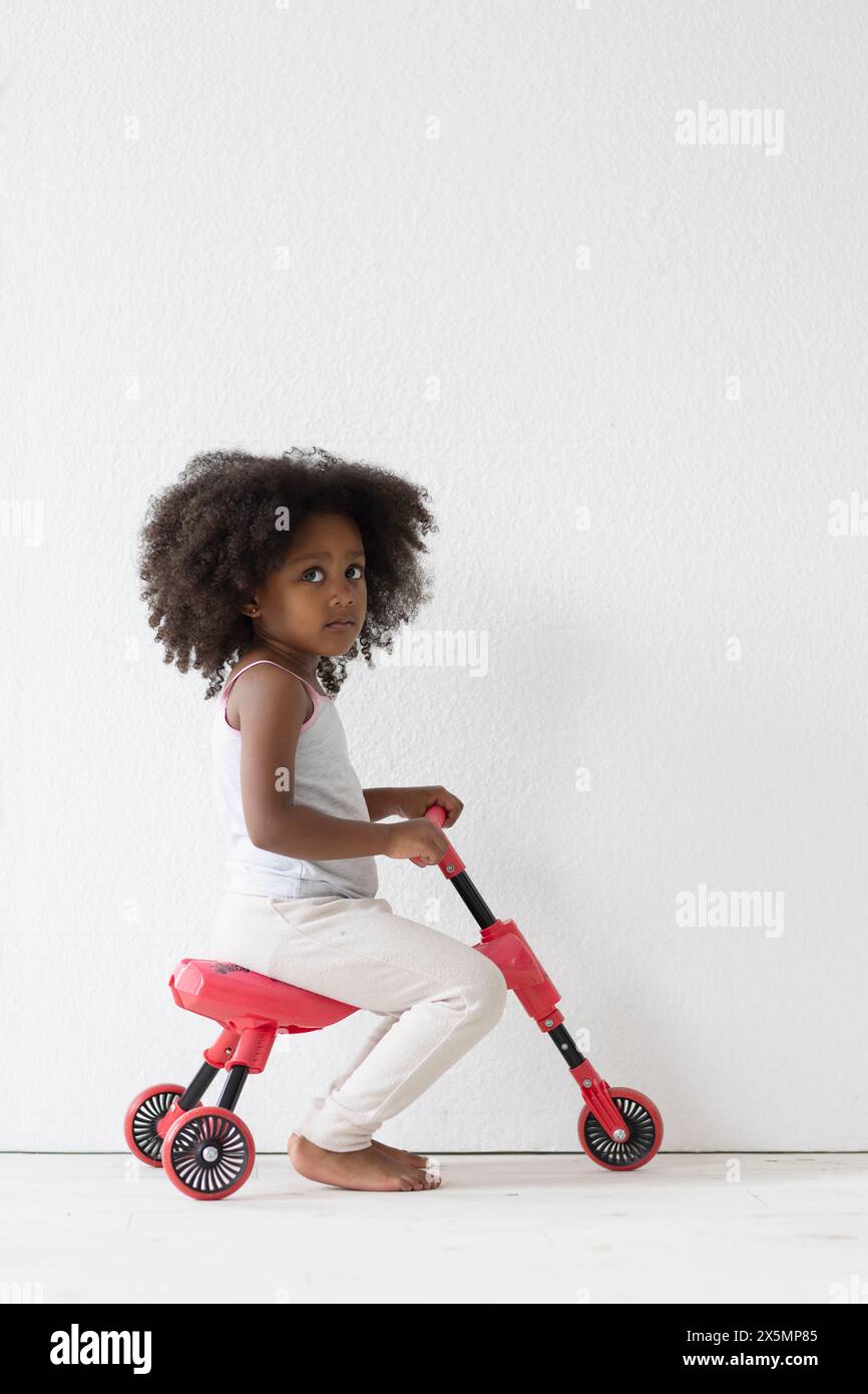 Portrait of girl riding on tricycle Stock Photo - Alamy