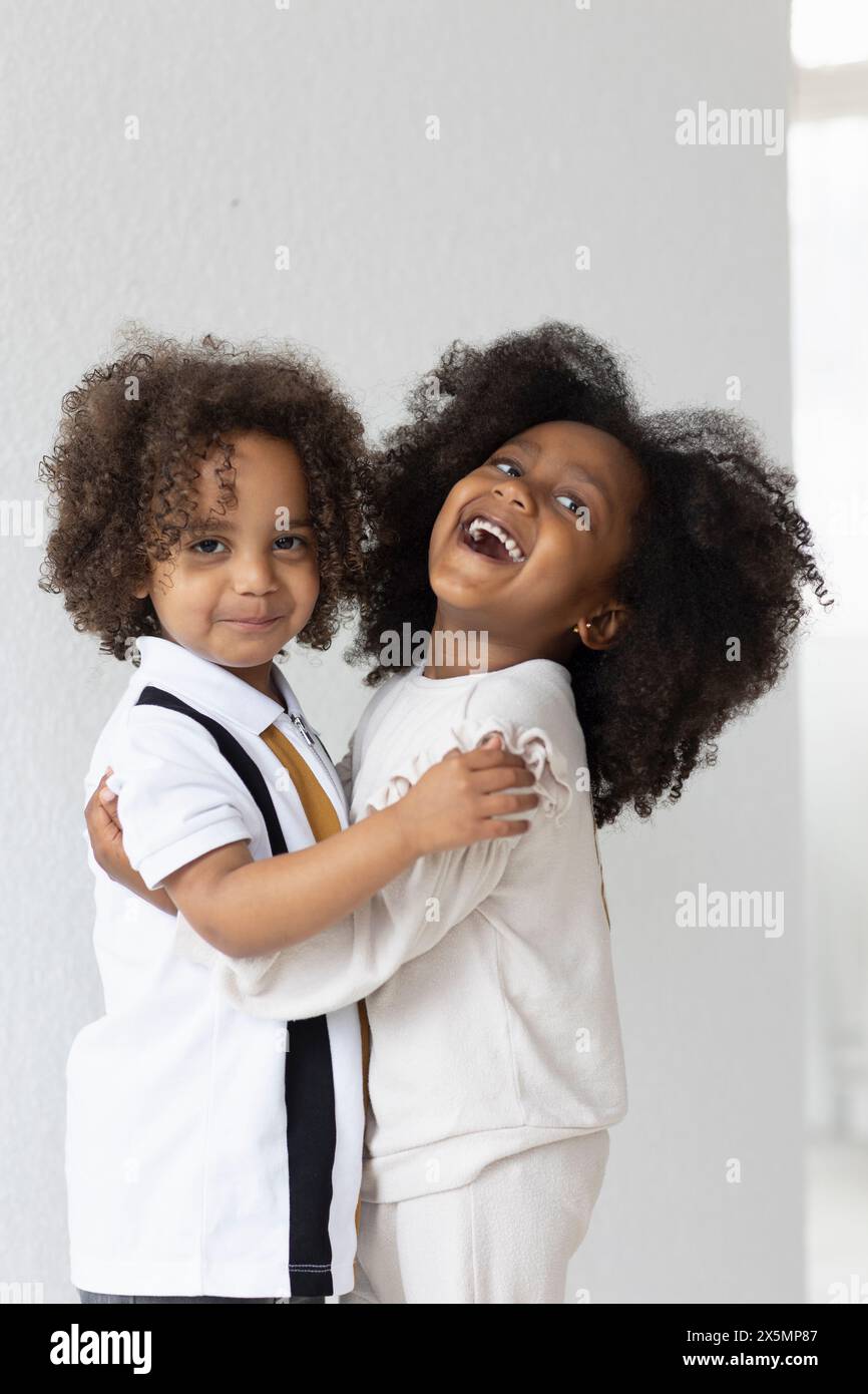 Portrait of smiling siblings embracing in front of camera Stock Photo ...