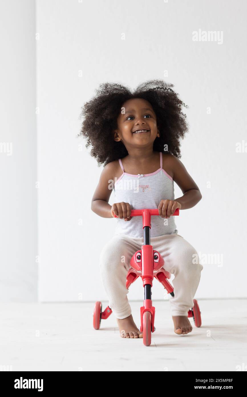 Portrait of girl riding on tricycle Stock Photo - Alamy