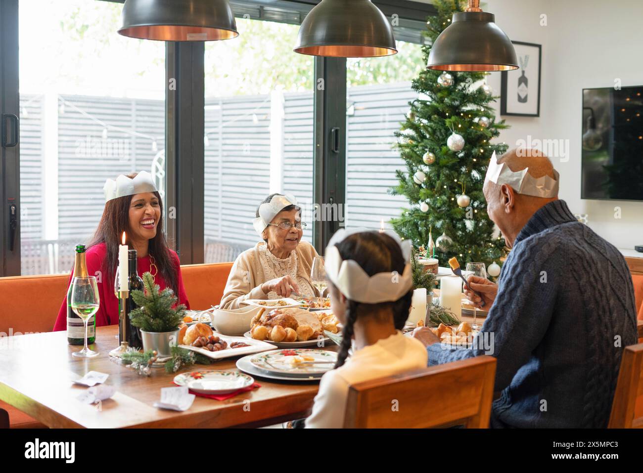 Family wearing paper crowns enjoying Christmas dinner Stock Photo - Alamy
