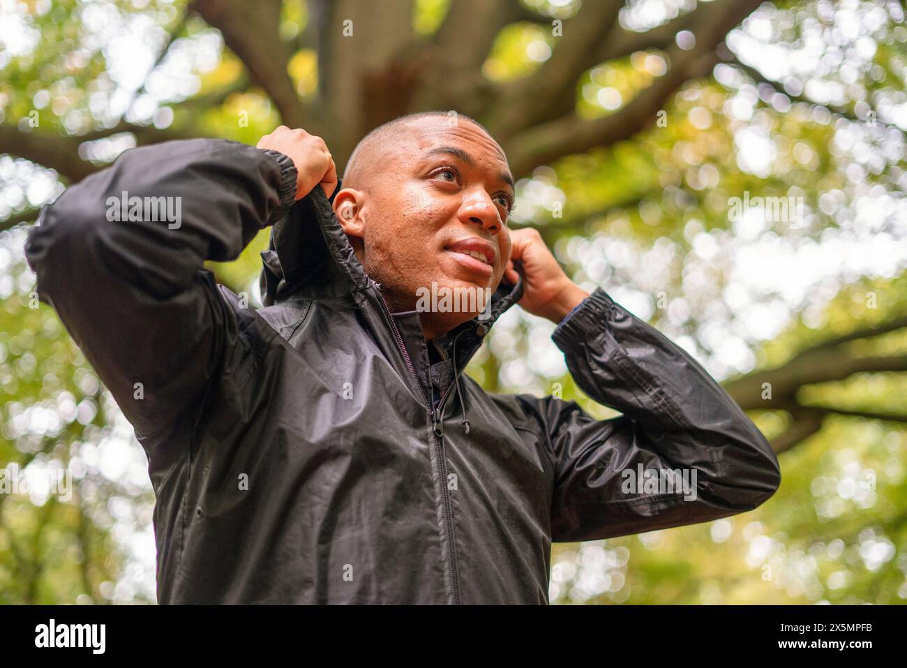 Man wearing rain jacket in forest Stock Photo - Alamy