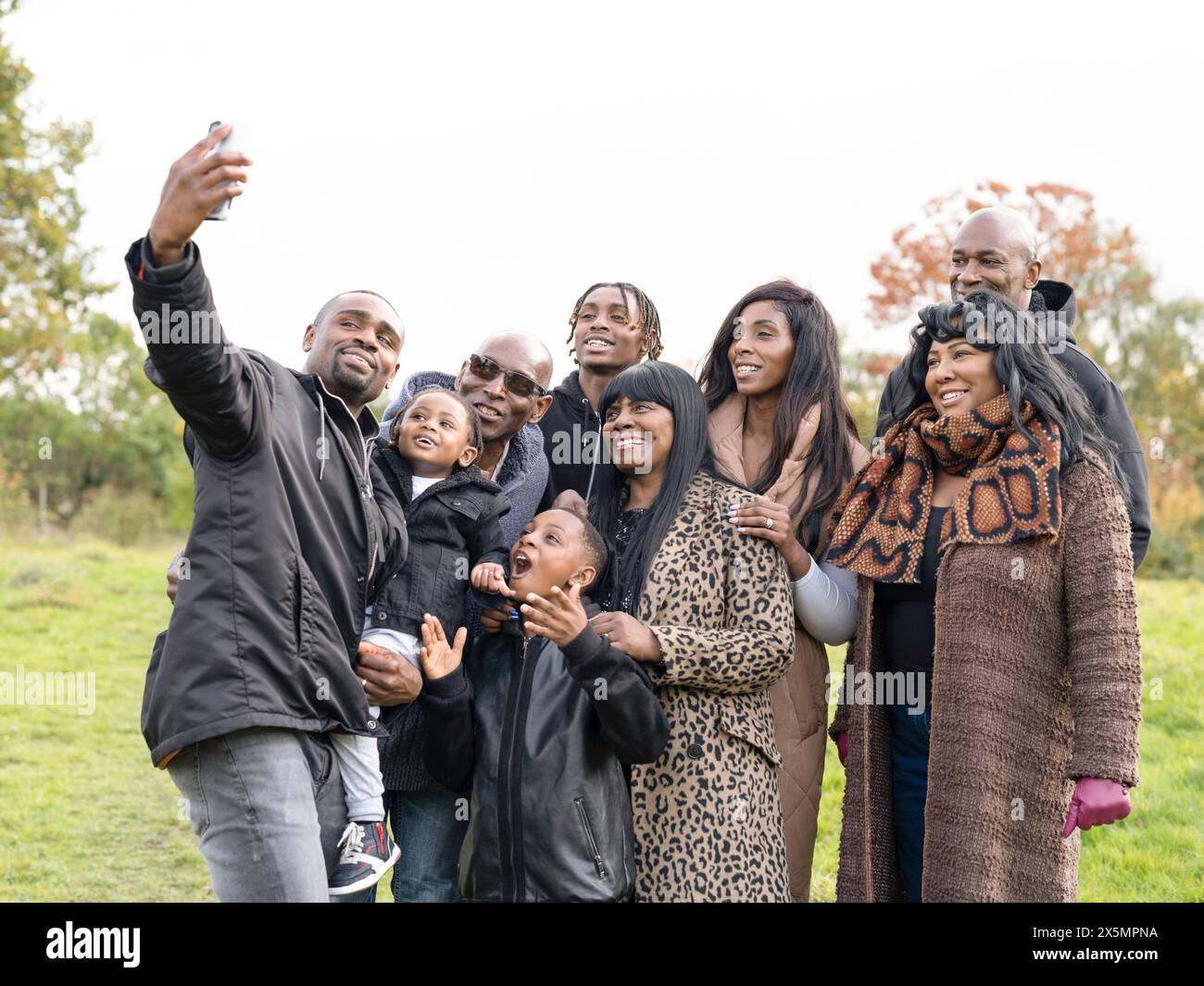 Portrait of multi-generational family taking selfie in meadow Stock ...