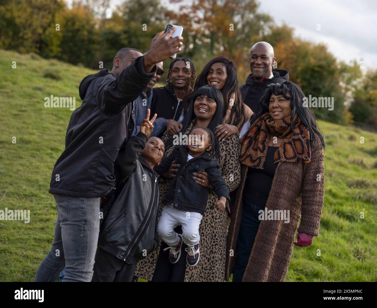 Portrait of multi-generational family taking selfie in meadow Stock ...