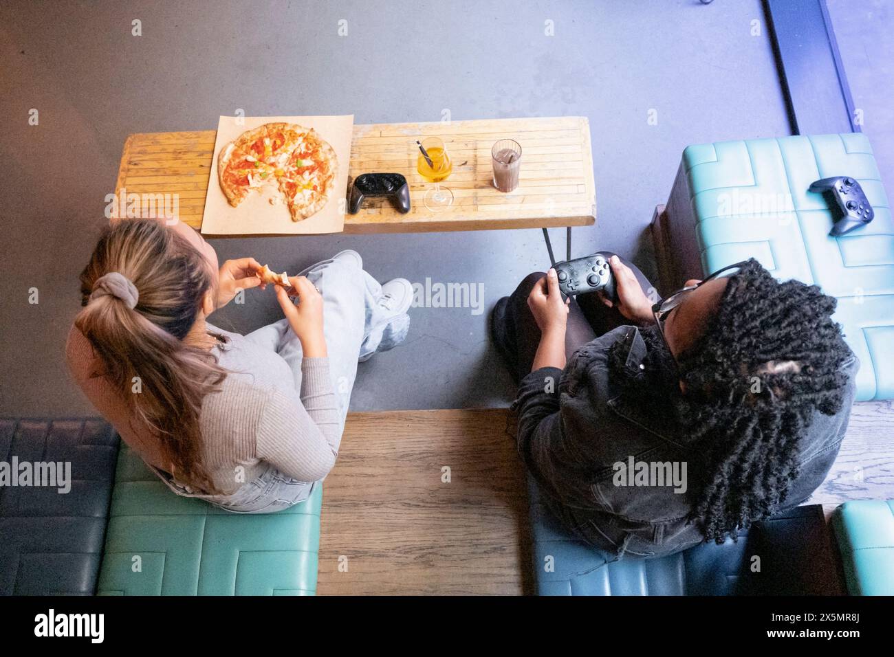 Women drinking and eating while playing in video games at pub Stock ...