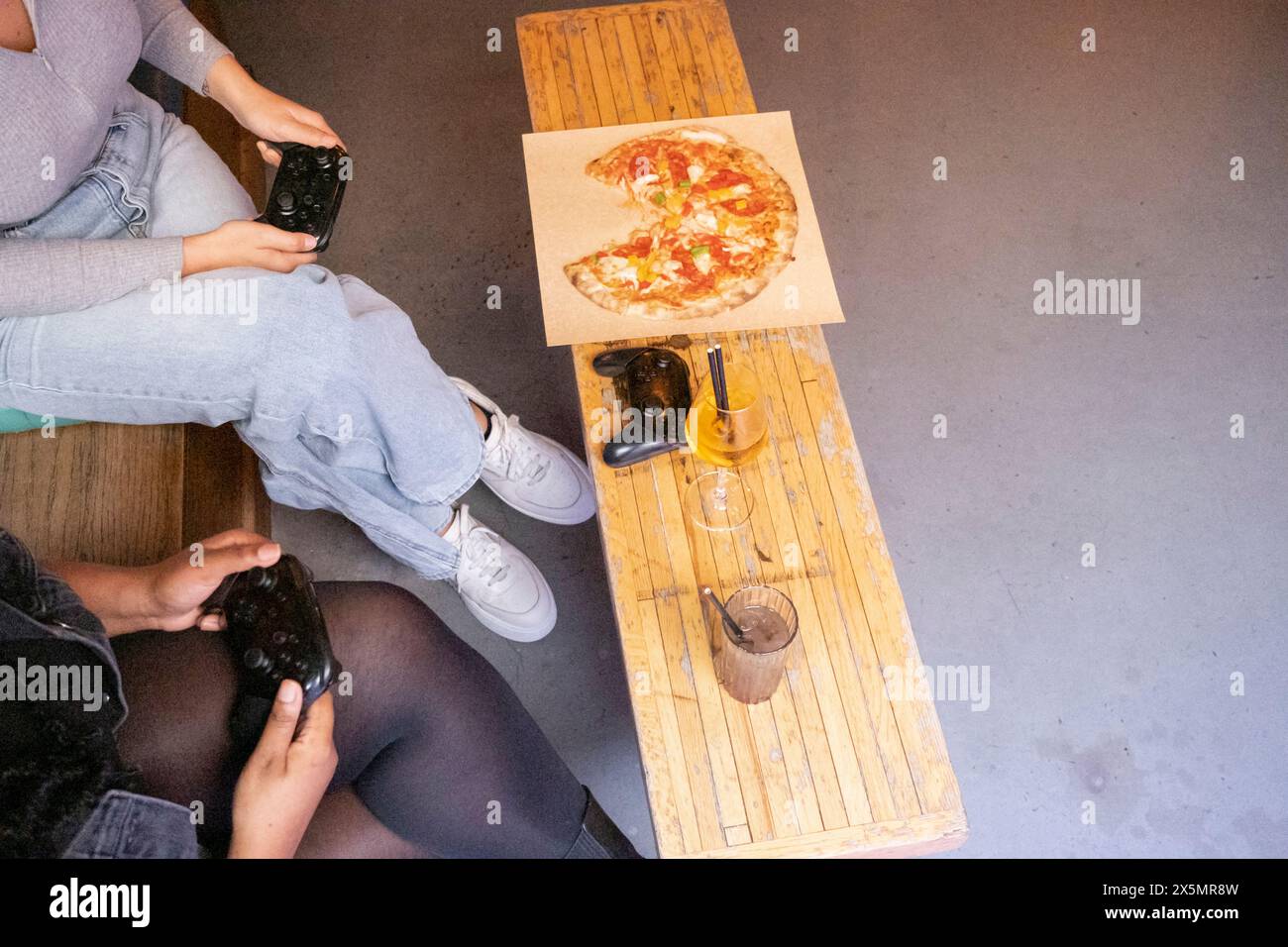 Women eating and drinking while playing in video games at pub Stock ...
