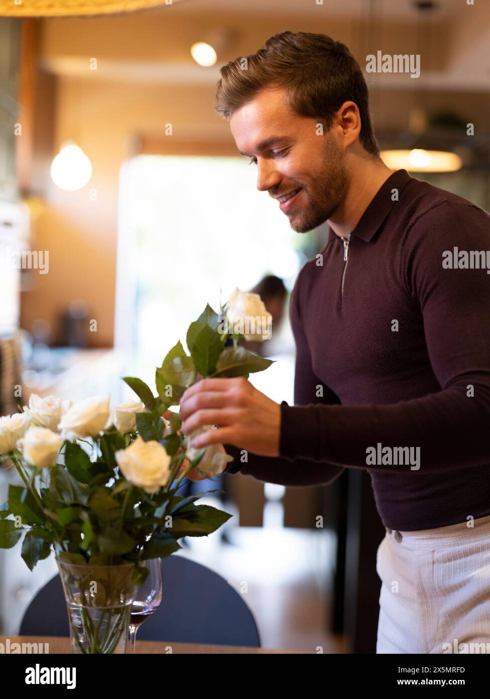 Man arranging rose flowers in vase Stock Photo - Alamy