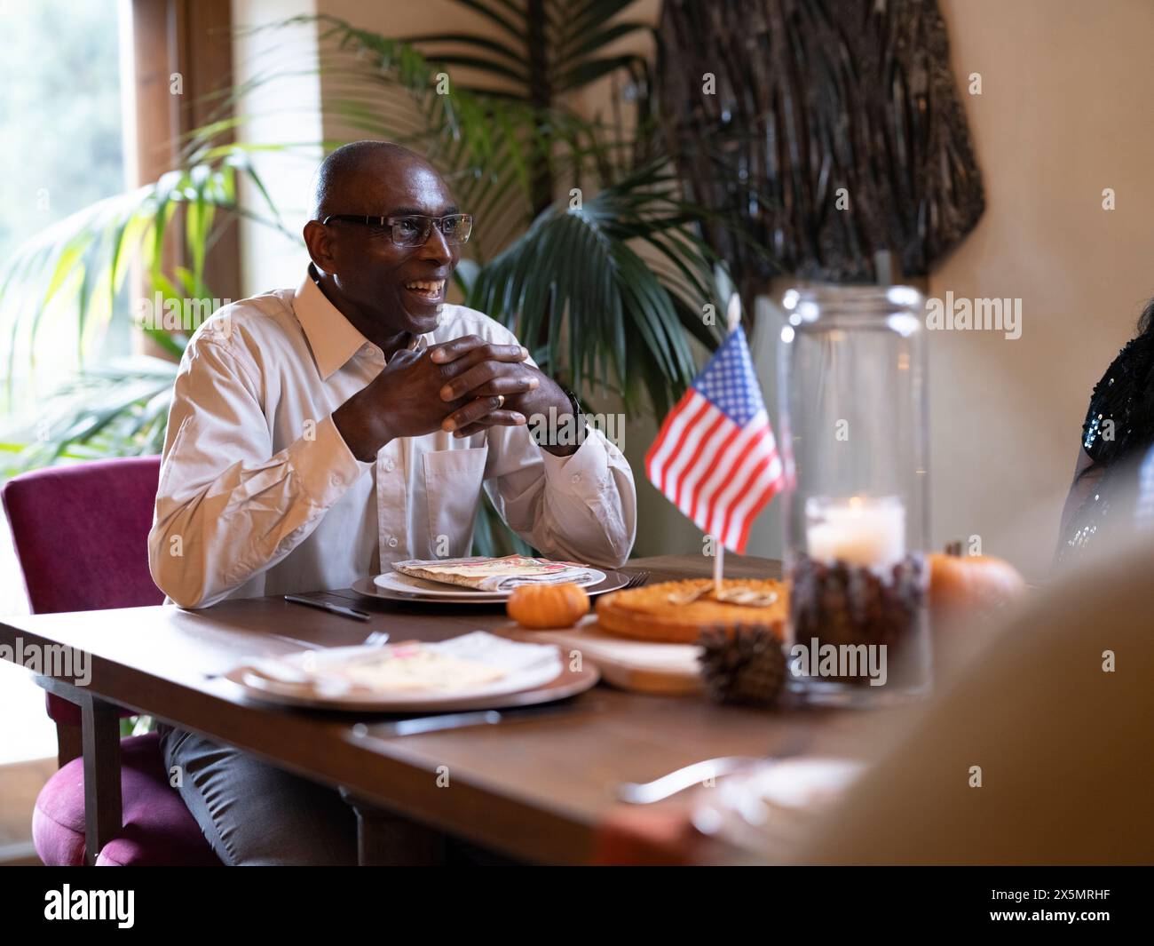 Smiling man sitting table hi-res stock photography and images - Alamy
