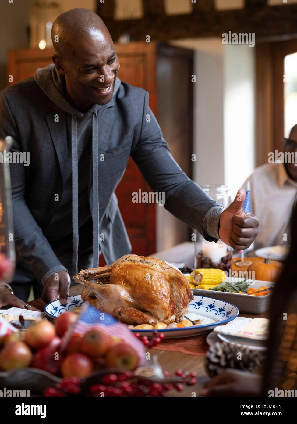 Man putting turkey on Thanksgiving table Stock Photo - Alamy
