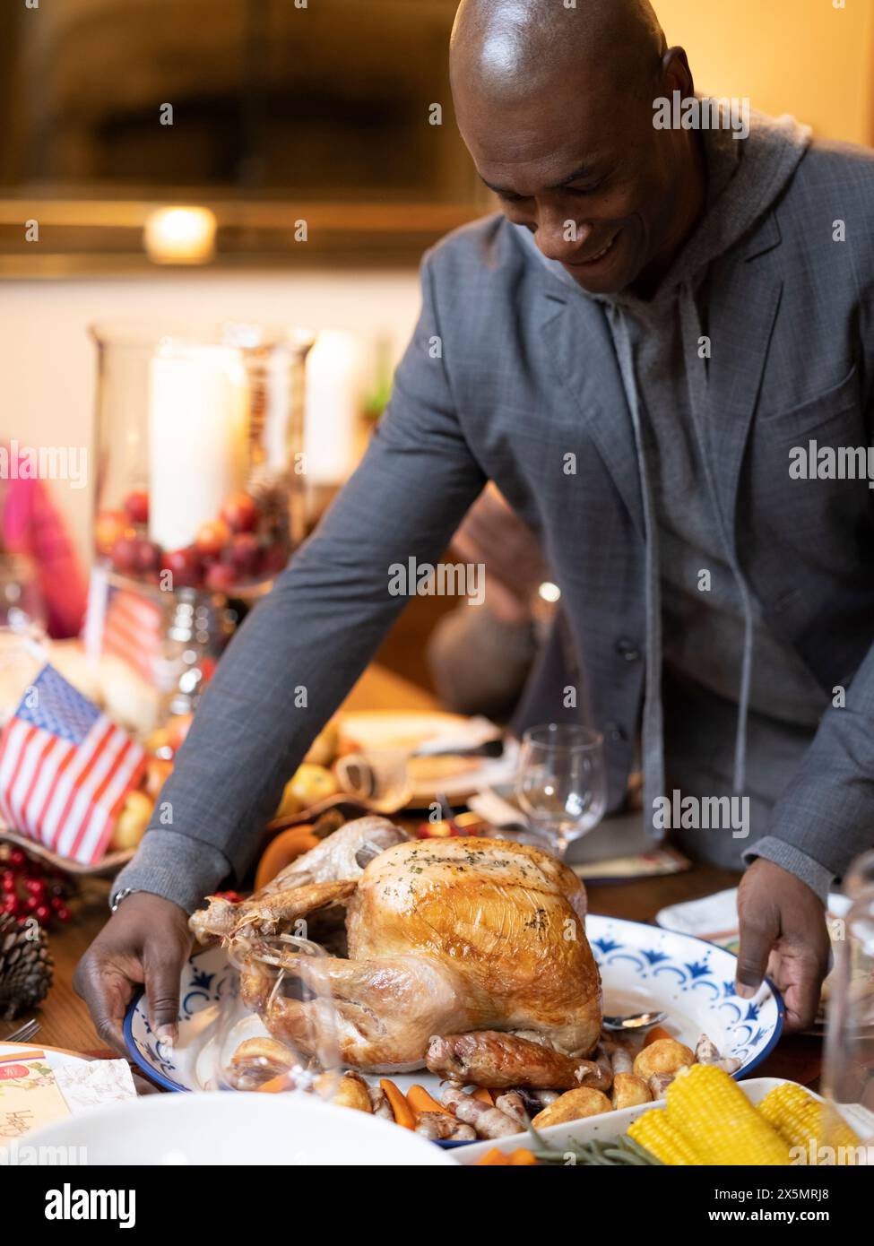 Man putting turkey on Thanksgiving table Stock Photo - Alamy