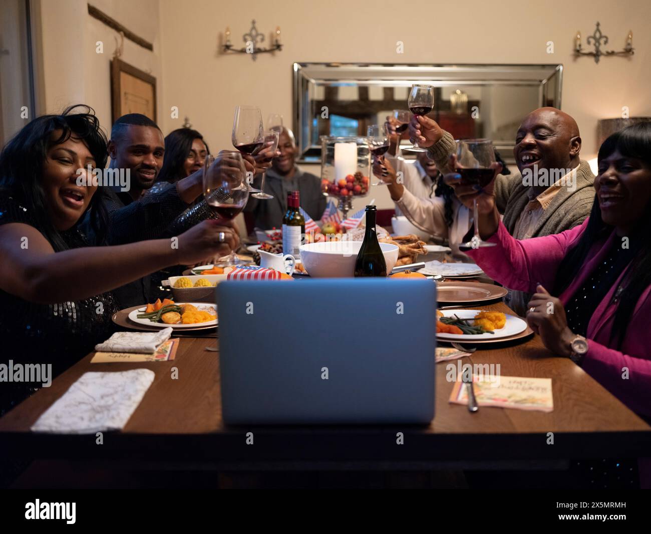 Family having video call and raising toast during Thanksgiving dinner ...