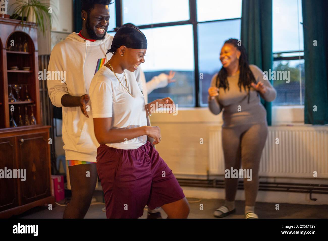 Friends laughing and dancing together in living room Stock Photo - Alamy