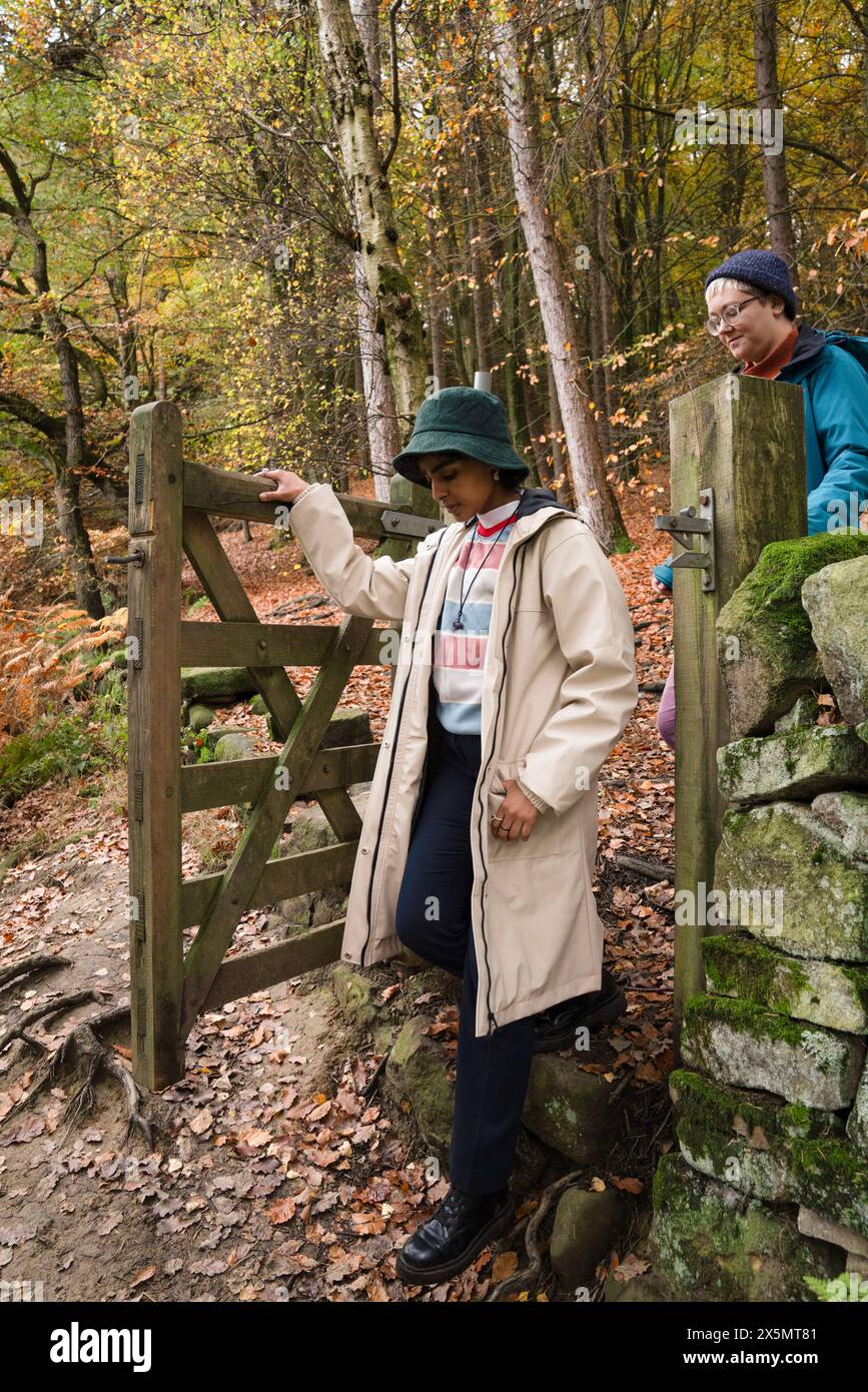 Female friends walking through gate in forest Stock Photo - Alamy