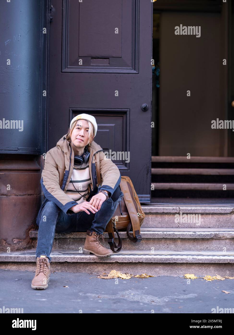 Portrait of man sitting on steps in front of building Stock Photo - Alamy