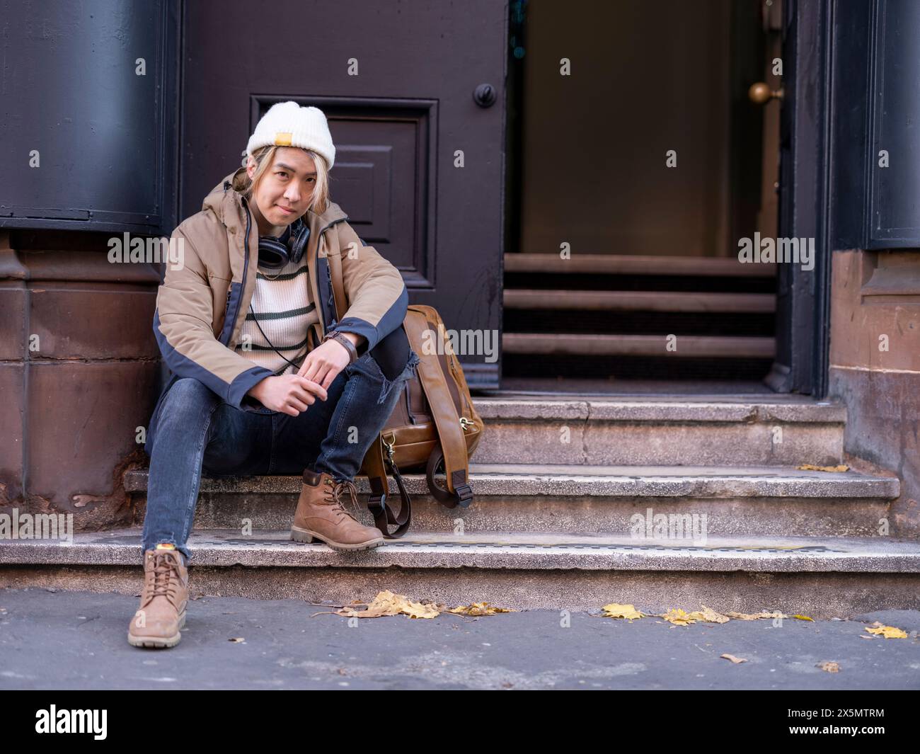Portrait of man sitting on steps in front of building Stock Photo - Alamy