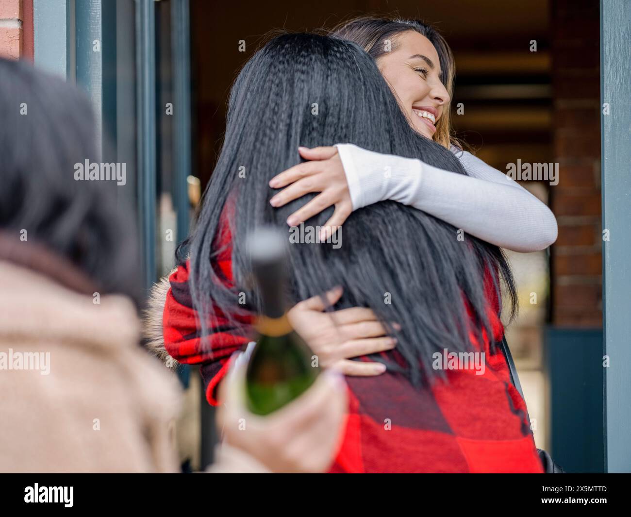 Women greeting at door while visiting friend in house Stock Photo - Alamy
