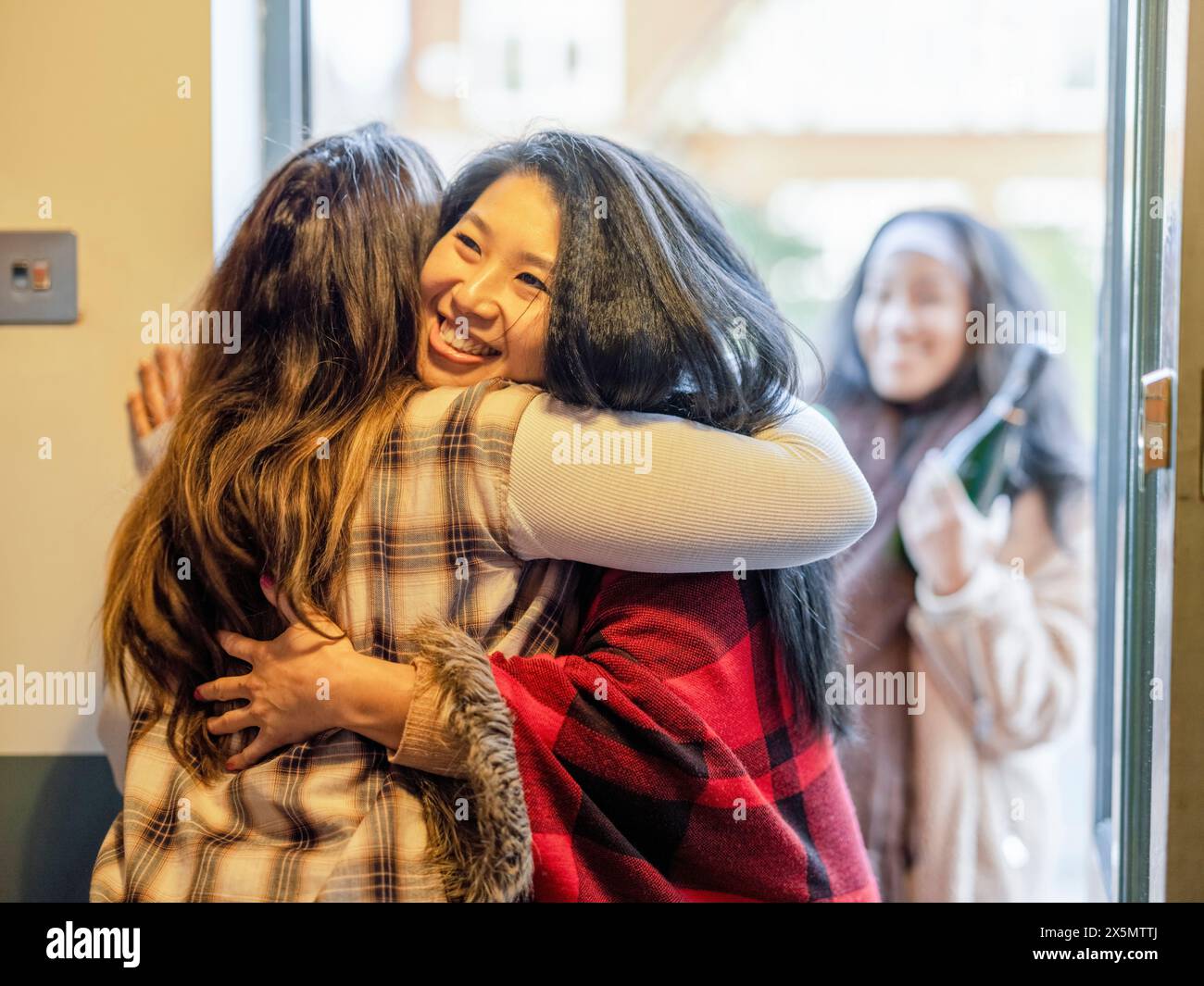 Women greeting at door while visiting friend in house Stock Photo - Alamy