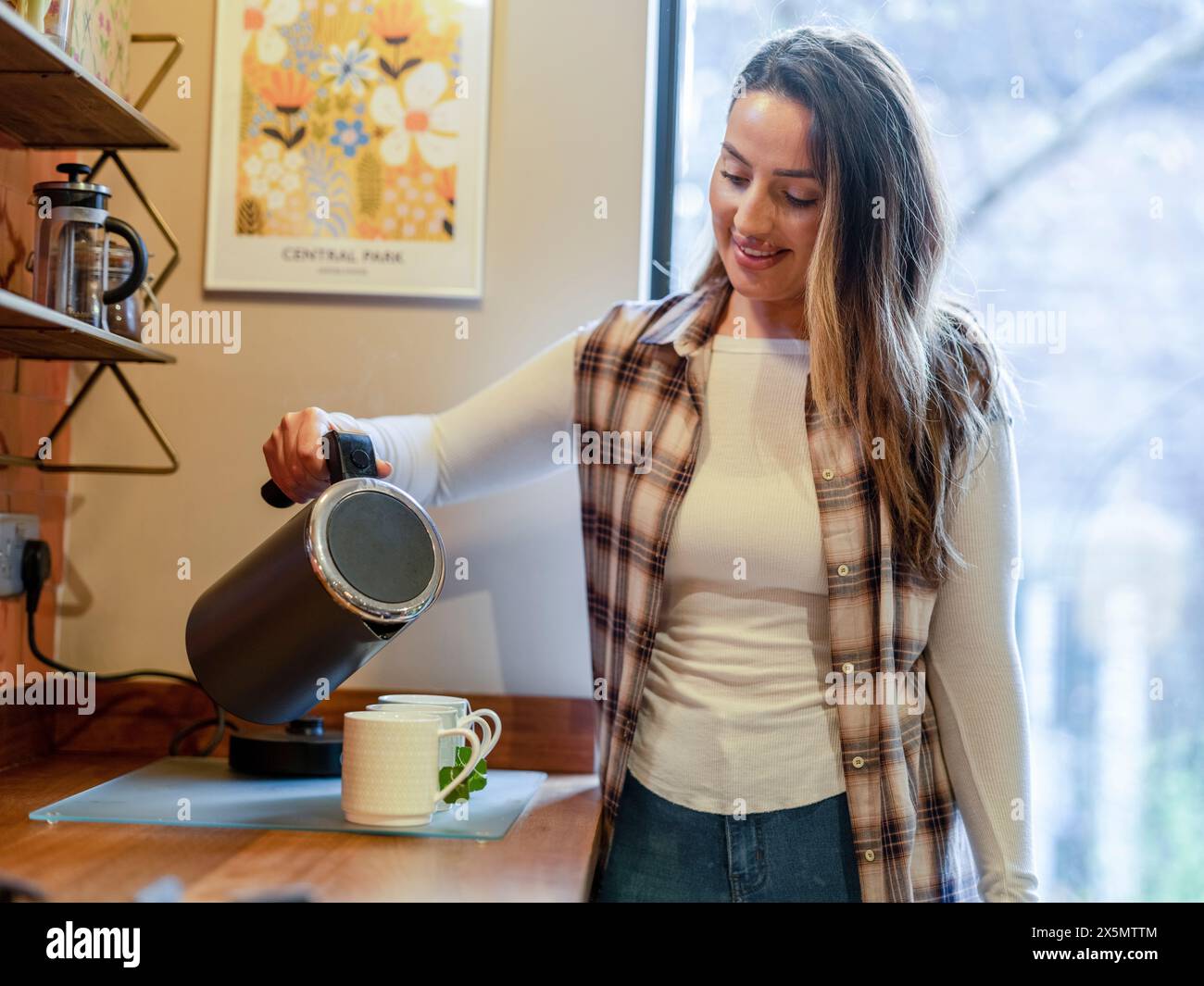 Woman pouring water into tea cup Stock Photo - Alamy