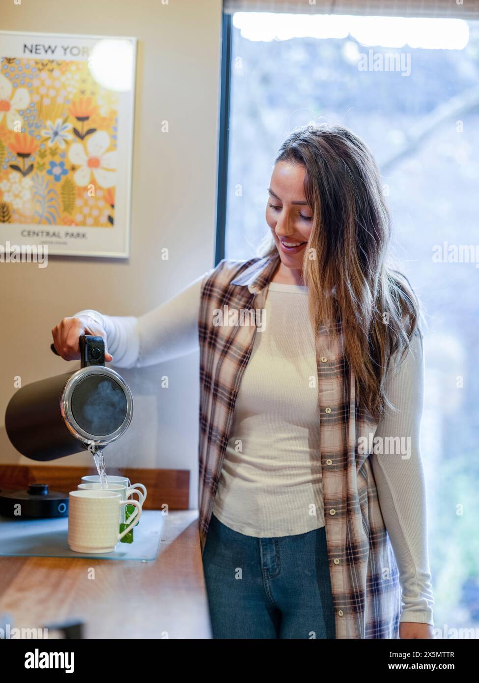 Woman pouring water into tea cup Stock Photo - Alamy