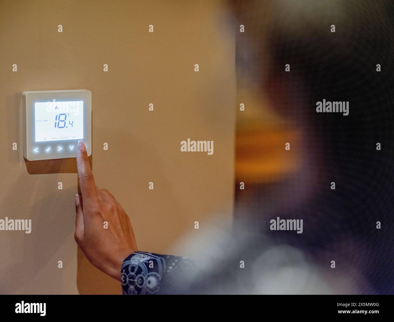 Woman adjusting home heating Stock Photo - Alamy