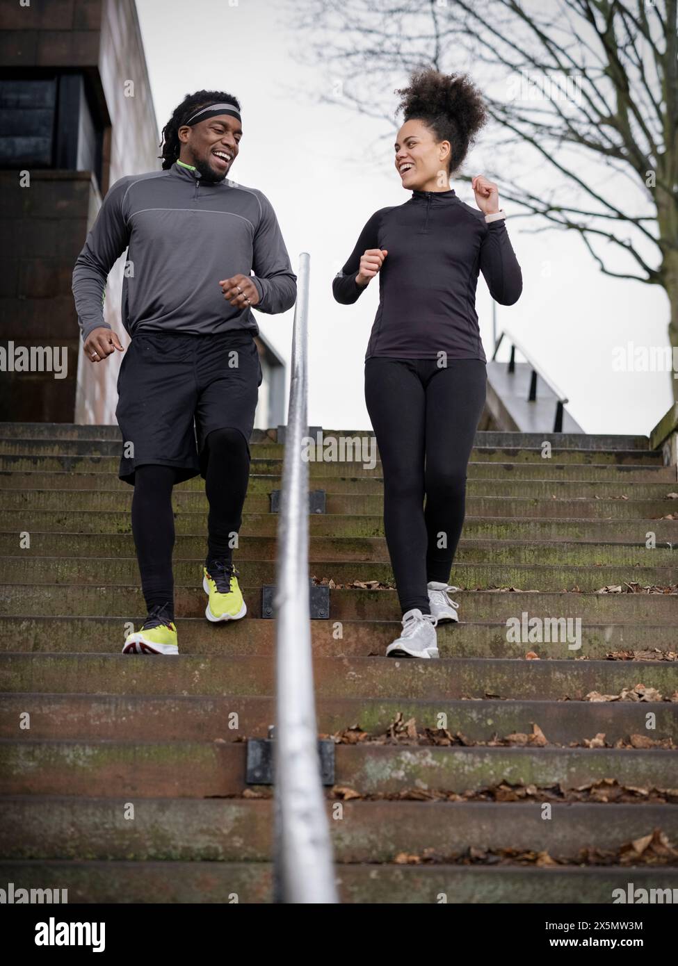 Athletic man and woman walking down steps outdoors Stock Photo - Alamy