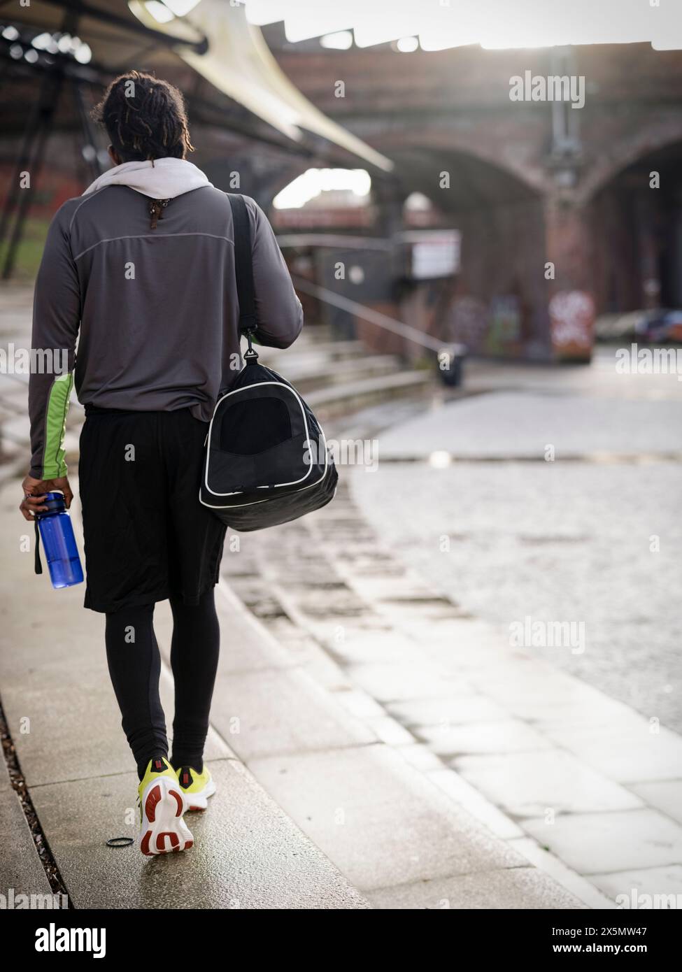 Rear view of athletic man with gym bag walking outdoors Stock Photo - Alamy