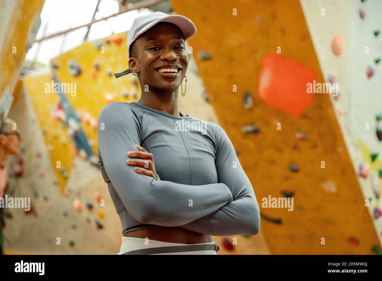 Portrait of smiling woman in front of climbing wall Stock Photo - Alamy