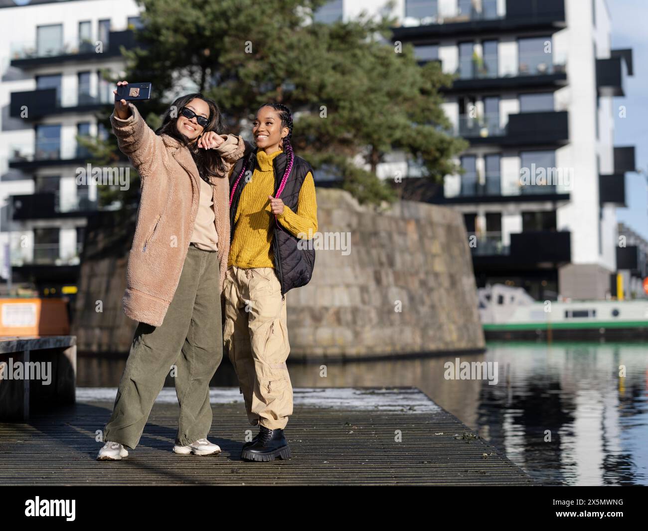 Two young women taking selfie in urban setting Stock Photo - Alamy