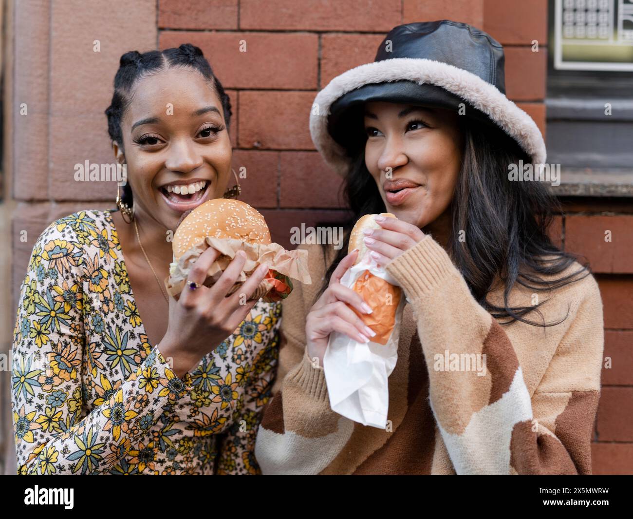 Two young women eating fast food Stock Photo - Alamy