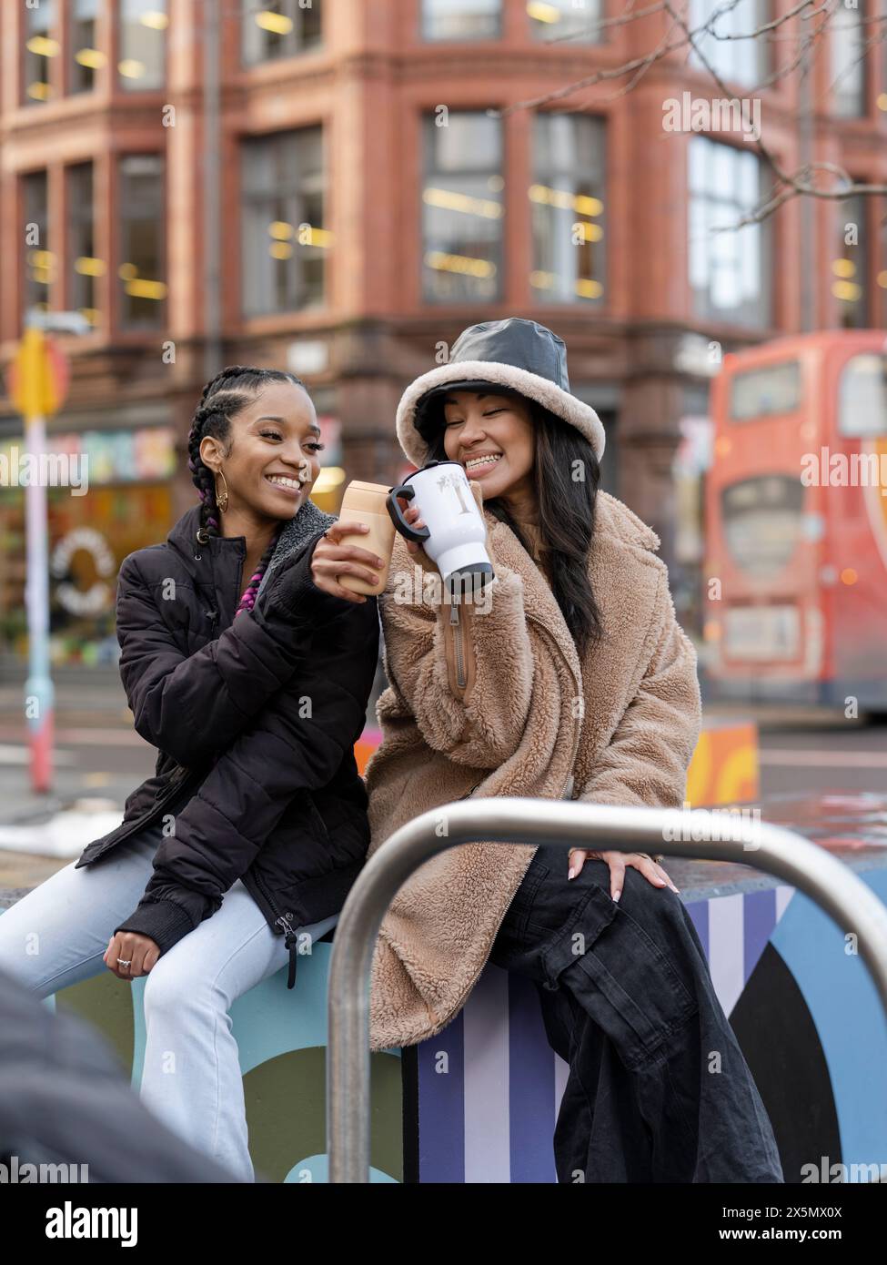 Two young women drinking coffee-to-go Stock Photo - Alamy