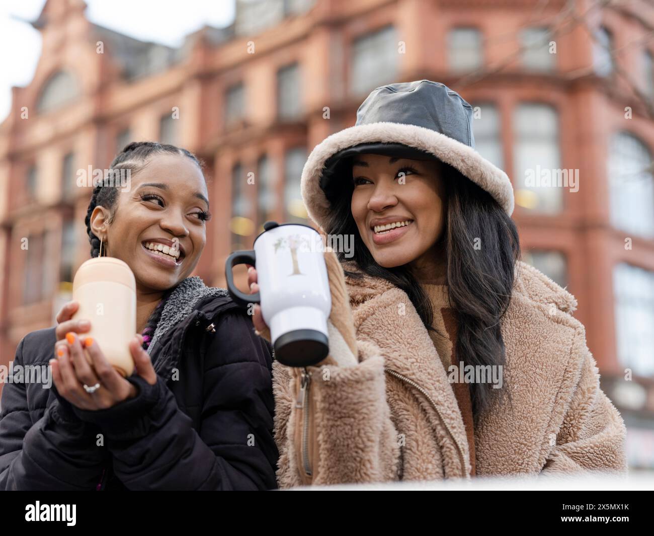 Two young women drinking coffee-to-go Stock Photo - Alamy