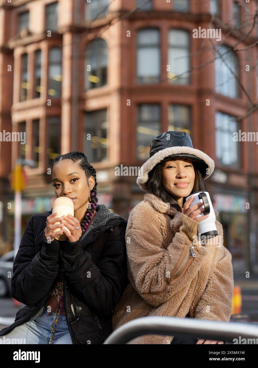 Two young women drinking coffee-to-go Stock Photo - Alamy