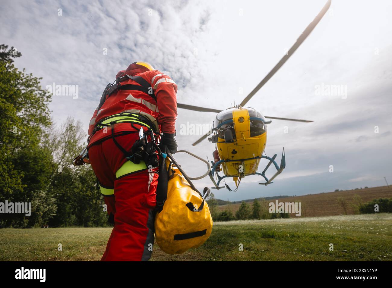 Paramedic with safety harness and climbing equipment running to ...