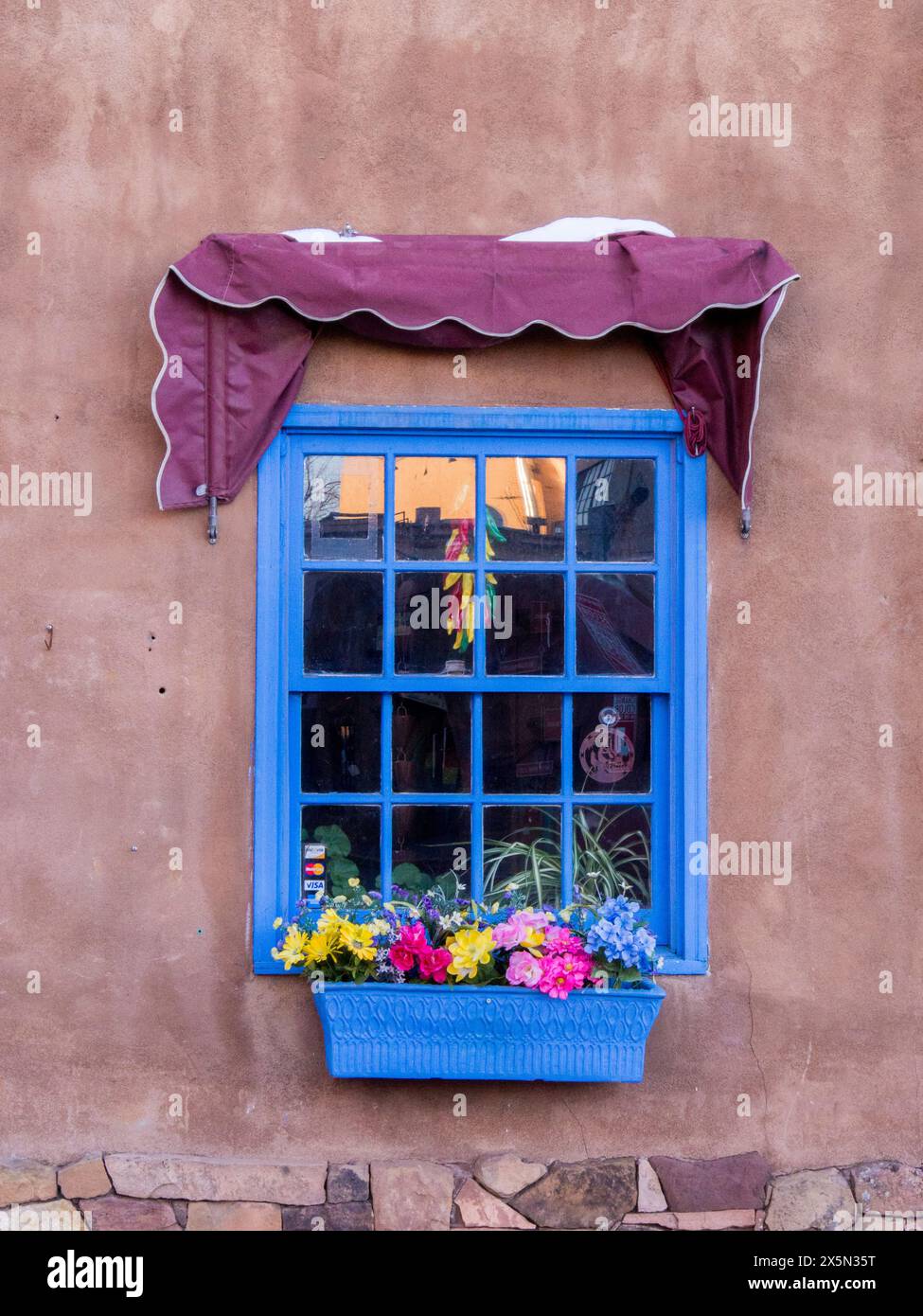 USA, New Mexico, Sante Fe. A decorative blue window with a flower box ...