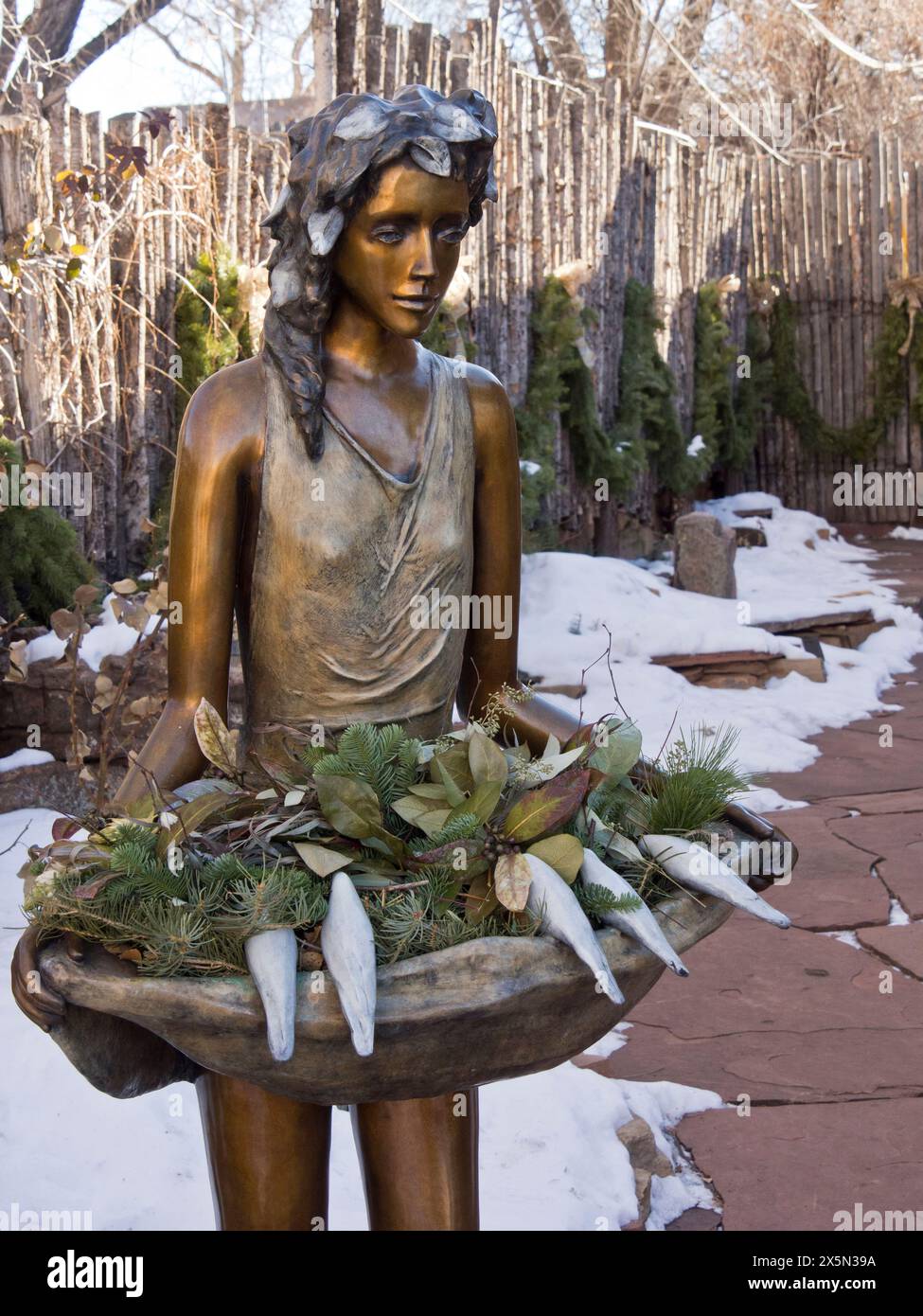 USA, New Mexico, Sante Fe. Bronze statue of a young woman holding a ...