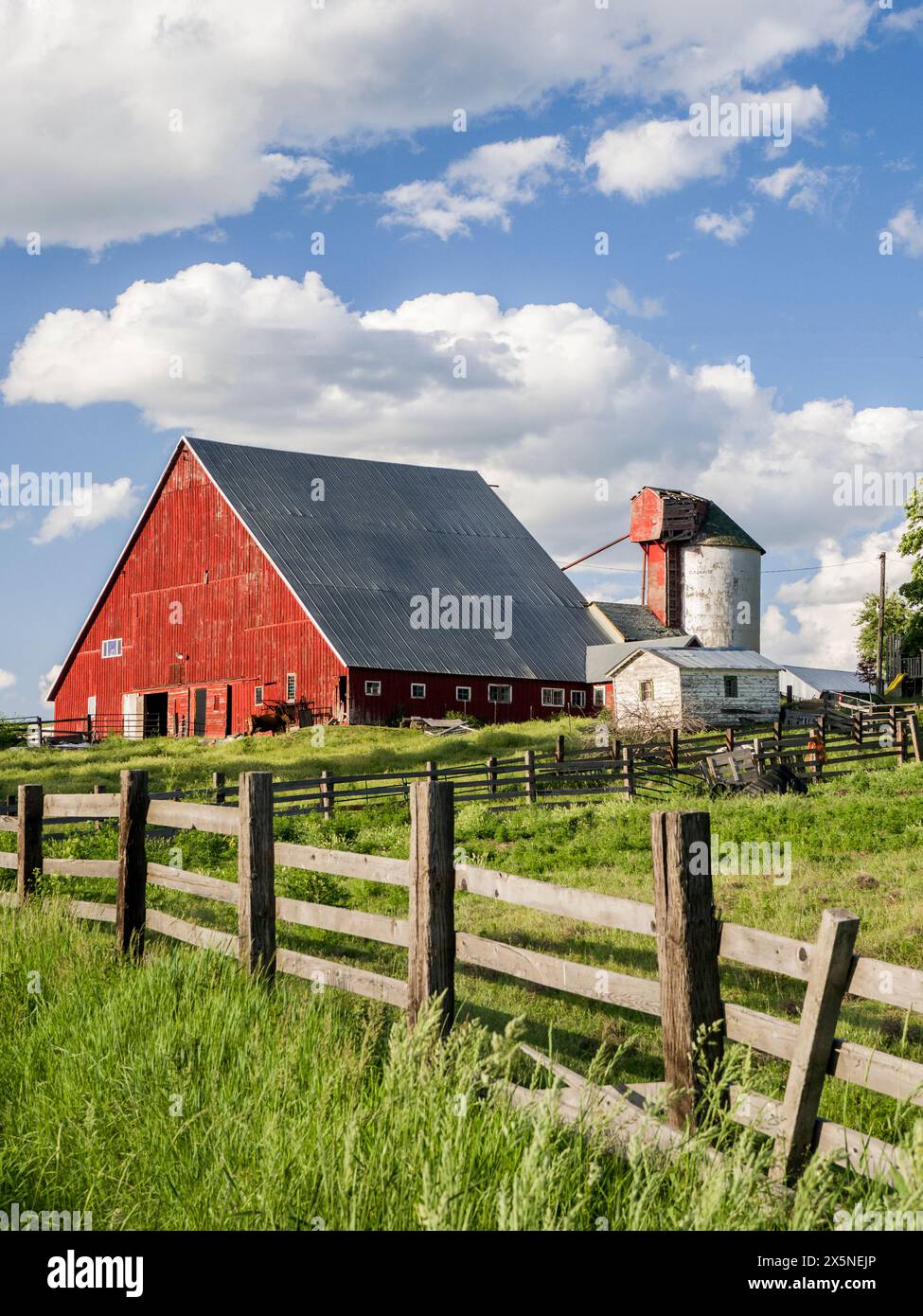 USA, Washington State, Palouse. Old fence line leading to a red barn ...