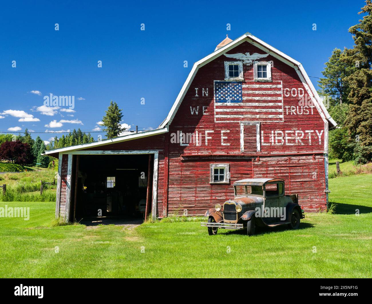 USA, Washington State, Palouse. Old car in front of the In god we trust ...