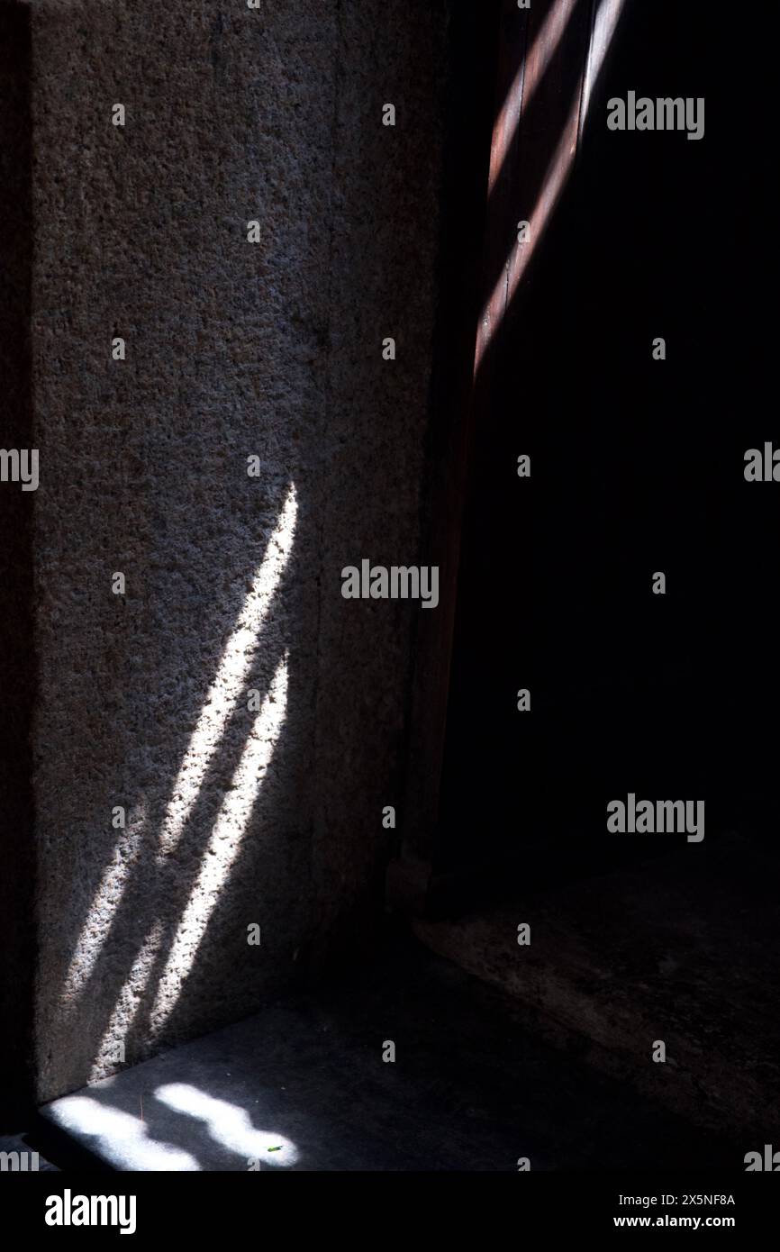 Shaft of light cuts through the dark on a window ledge Stock Photo - Alamy