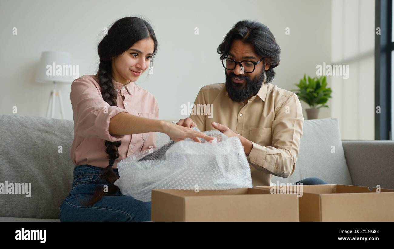 Happy couple customers receive parcel look inside box Arabian Indian ...