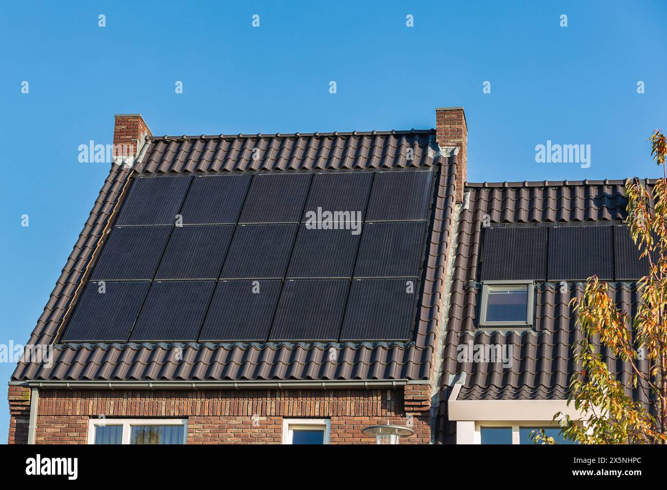 Solar panels on the tiled roof of a brick house on a sunny day Stock ...