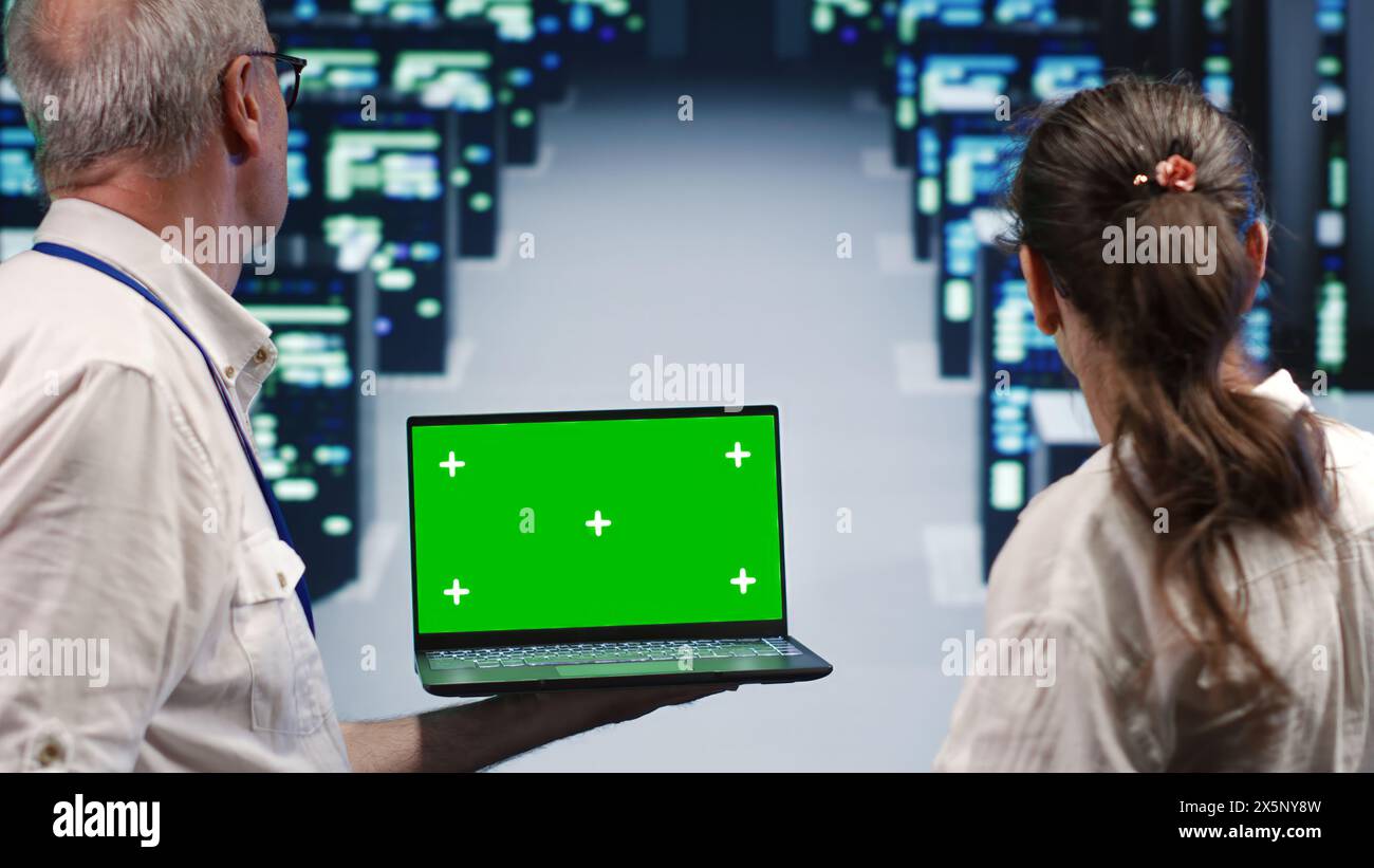 Skilled specialists looking around high tech data center, using mockup ...