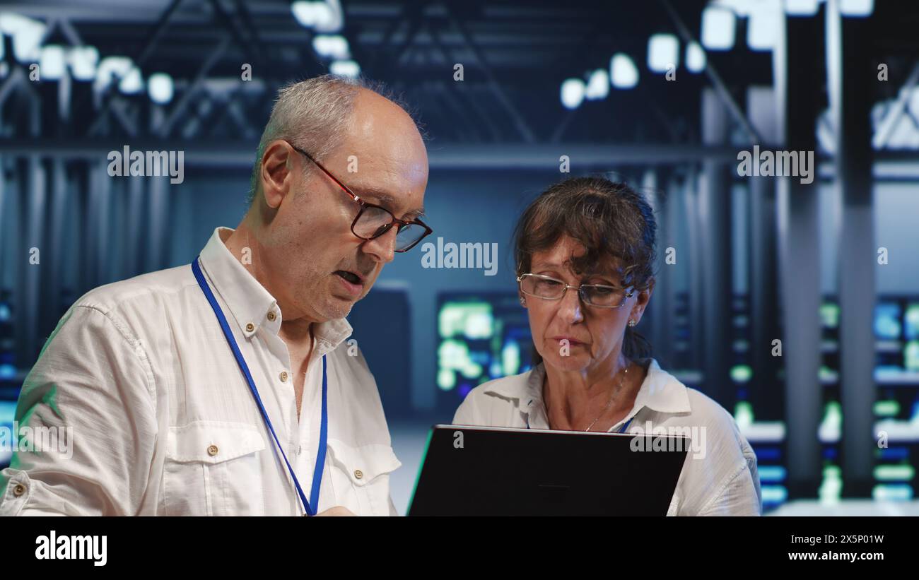Efficient technical support executives looking around server hub, using ...